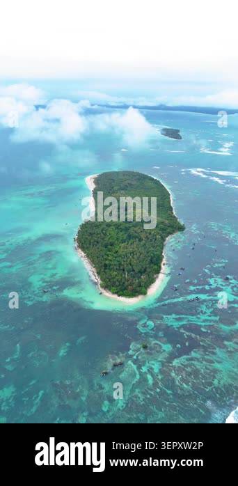 Aerial drone shot flying over a stunning tropical island with lush ...
