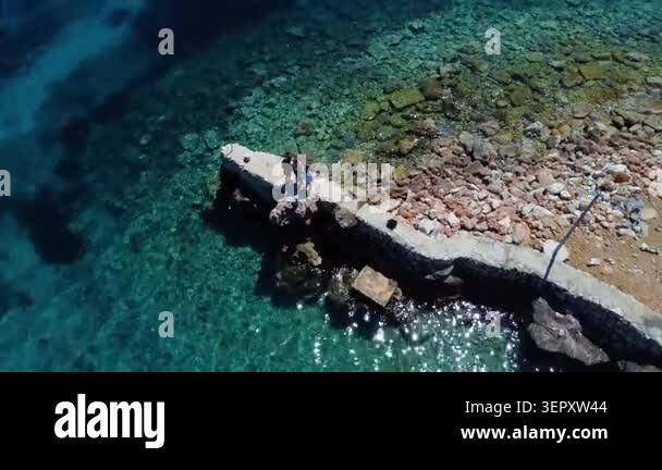 Aerial view of a small group of friends standing on a concrete pier ...