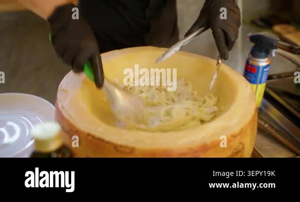 Pasta preparation. Italian cuisine. Chef mixing hot parmesan cheese ...