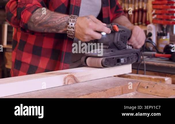 Carpenter occupation. Joinery process. Man smoothing board surface with ...