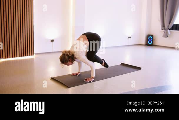 Arm balance. Fitness training. Female standing on hands in bakasana ...