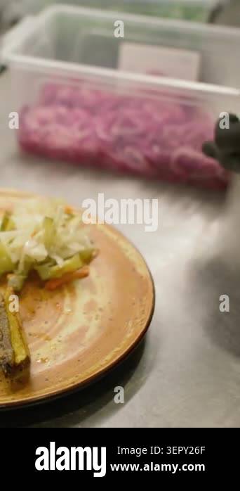 Vertical video. Serving food. Meal plate. Hand in black gloves putting ...