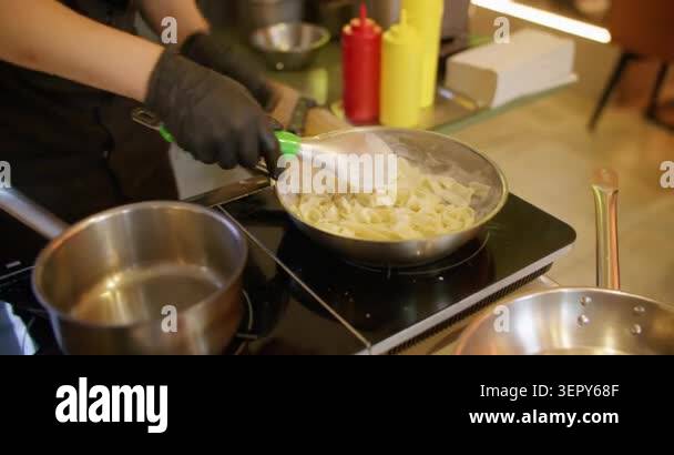 Preparing spaghetti. Culinary process. Chef glove hand stirring hot ...