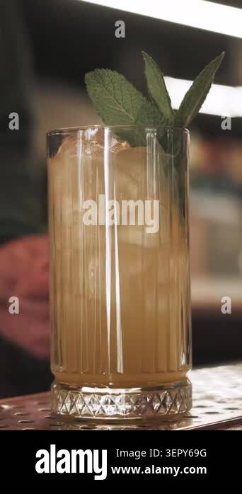 Vertical video. Cold drink. Served cocktail. Bartender hand garnishing ...