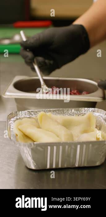 Vertical video. Serving food. Catering kitchen. Chef hand in gloves ...