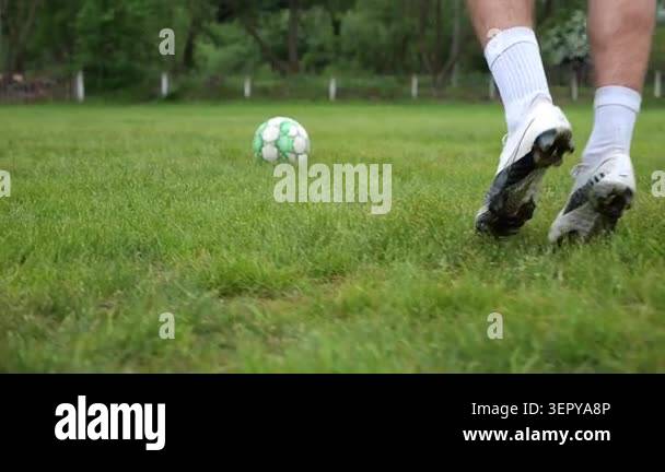Leg of sportsman shooting a penalty kicks on stadium at summer day ...