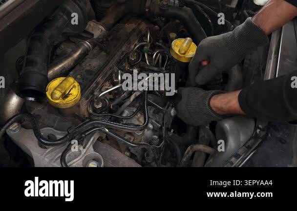 Close-up of a mechanic repairing a car engine in an auto workshop ...