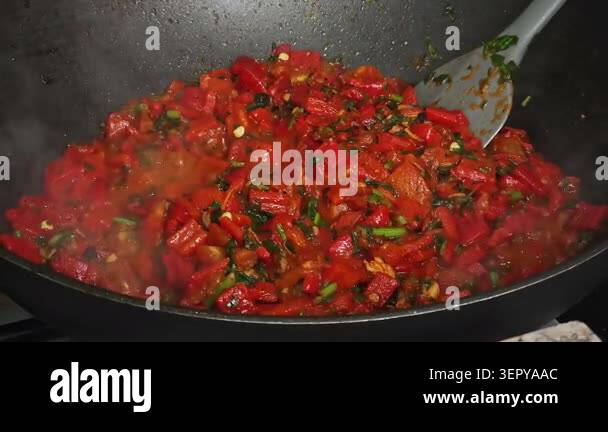 Traditional Moroccan roasted pepper salad cooking in a frying pan over ...