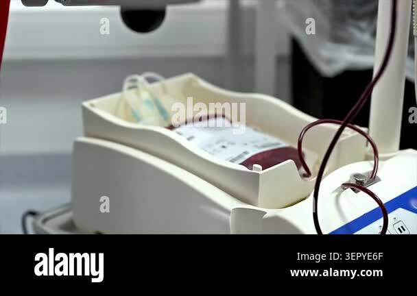 Close-up of a blood bag filling with donated blood on an agitator and ...