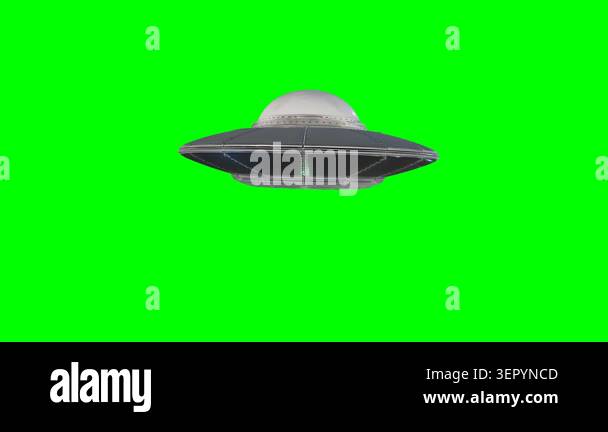 Metallic flying saucer UFO spins and hovers against a bright green ...