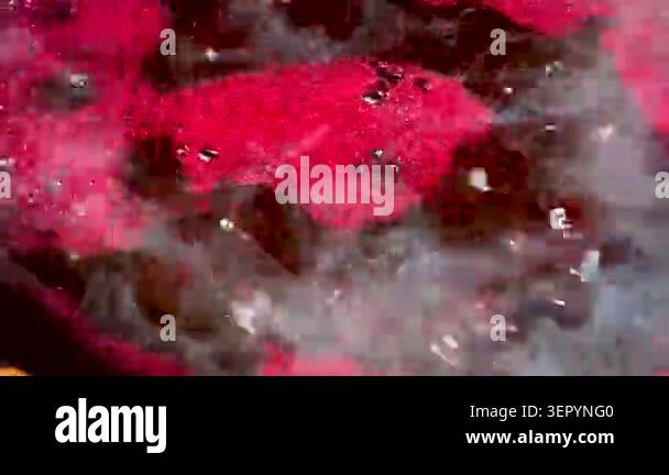 Close up top-down view of boiling red and purple liquid dye with rising ...