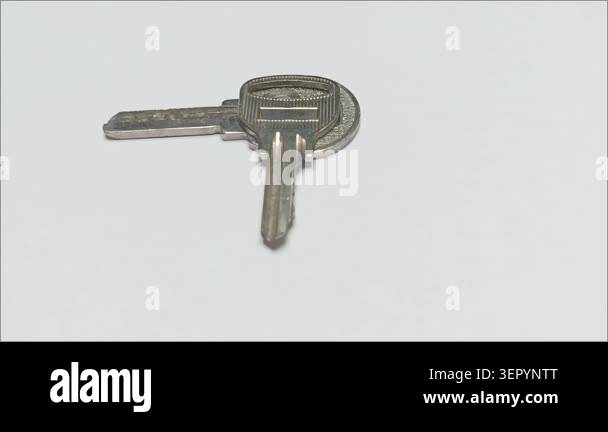 Close up view of two metallic house keys overlapping on a white ...