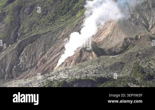 Volcanic activity with steam and smoke rising from the crater of a ...