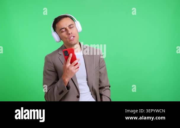 Businessman wearing headphones dancing and listening to music from his ...