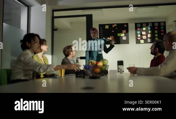 A team gathers in an office to discuss plans and strategies ...