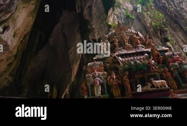 Visitors look up at the Batu Caves in Malaysia. The colorful Hindu ...