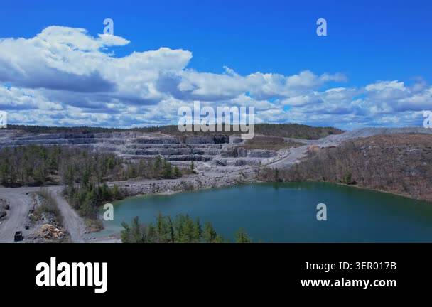 Turquoise lake water near open pit mine operation with sky. Mining ...
