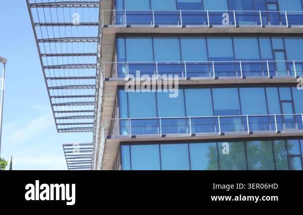 Modern glass building with balconies and metal framework. Sky is clear ...