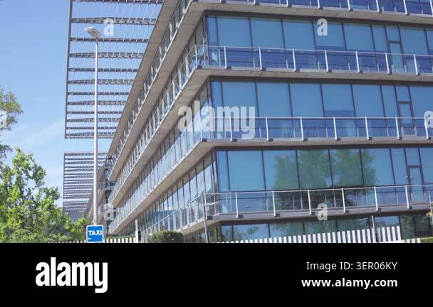 Modern glass building with balconies under clear sky. Reflective ...