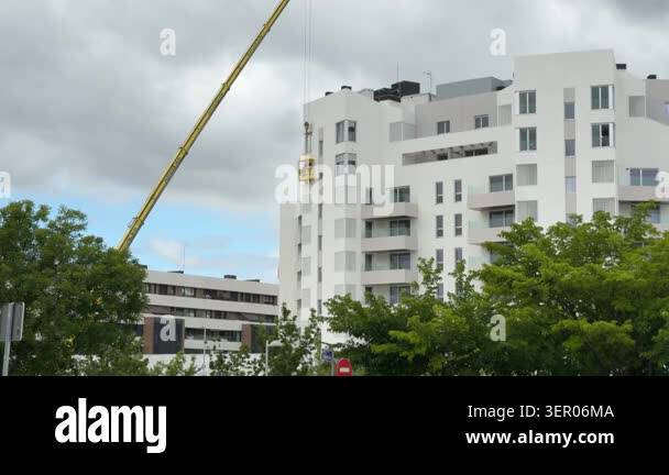 Construction crane operating next to a modern residential apartment ...