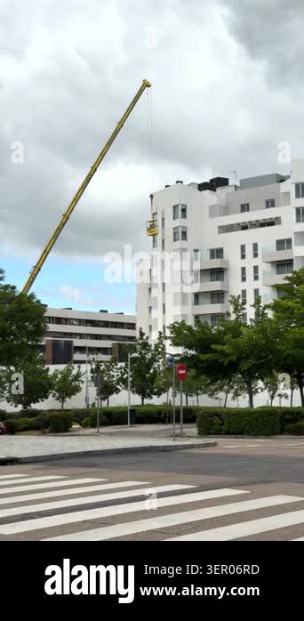 Construction crane operating next to a modern residential apartment ...