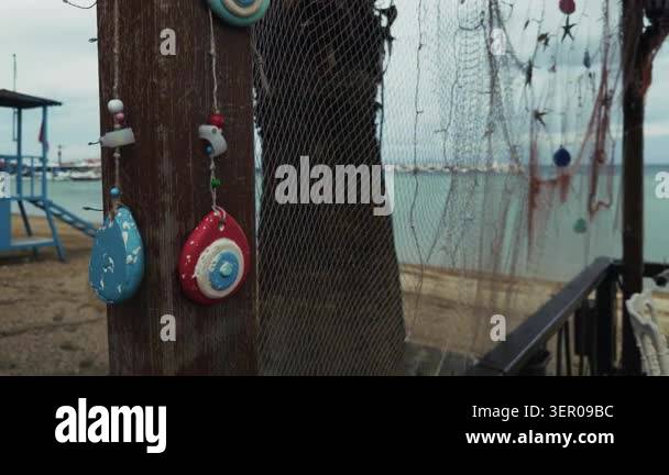 Traditional fishing net decorated with a blue evil eye bead hanging by ...
