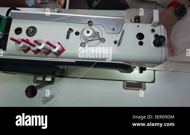 Close up view of a tailor sewing fabric on a sewing machine, focused on ...