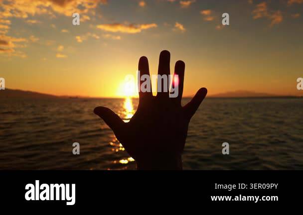 Hands reaching toward the warm sunset light, symbolizing hope ...