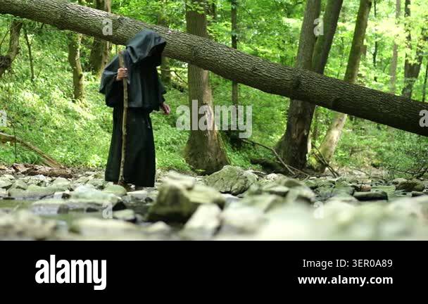 Religious wanderer explores a natural area near water while continuing ...