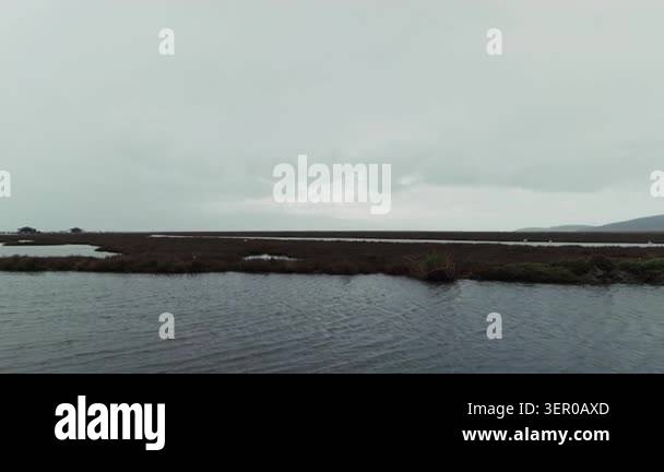 A moody landscape view of a wet asphalt road through a car window ...