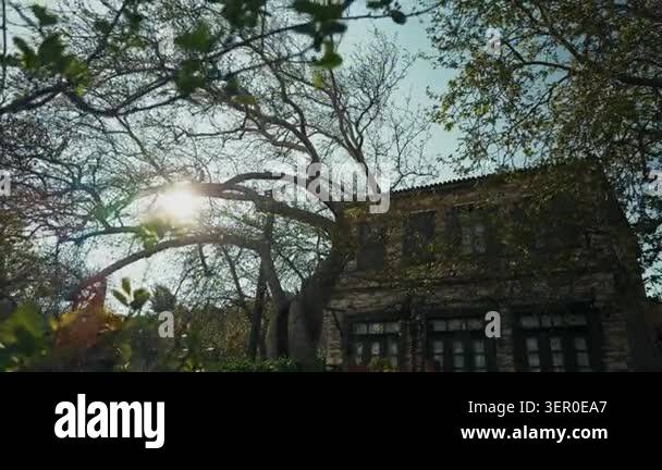 A traditional stone house nestled among lush green trees in the ...