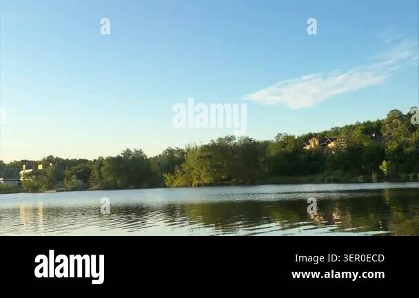 Two paddle boarders glide across a quiet river at sunrise. The tranquil ...