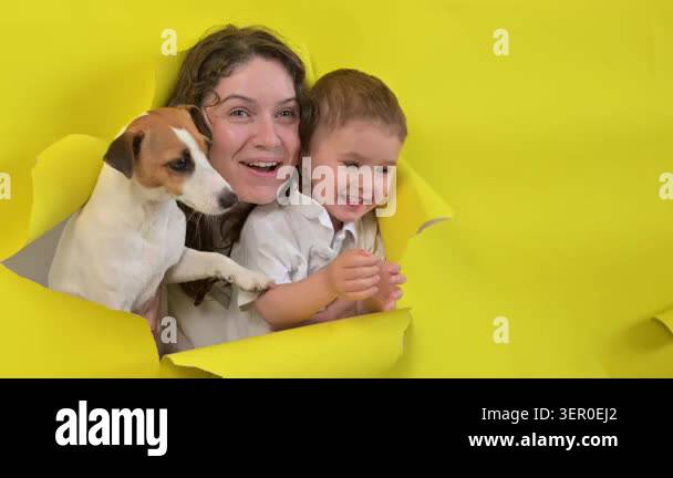 Cheerful young mother with curly brown hair and her toddler son wearing ...