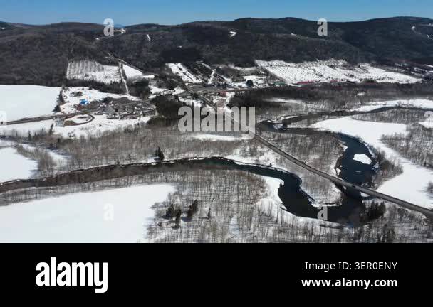 Panoramic drone footage of the Matapedia River winding through snowy ...