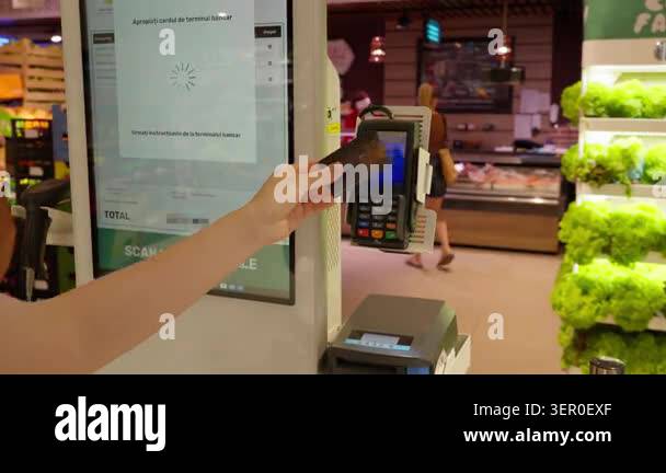 Close-up footage of a customer using a contactless bank card at a self ...