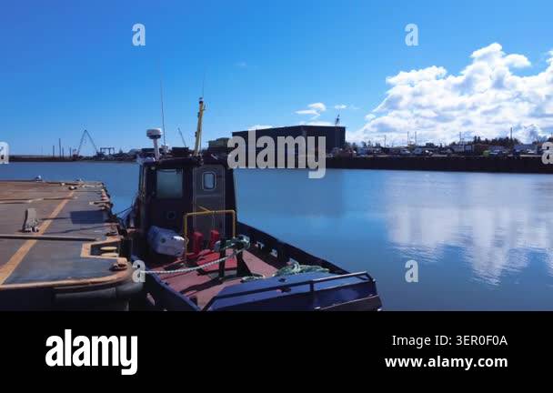 Peaceful harbor atmosphere showcasing a moored tugboat, clear ...