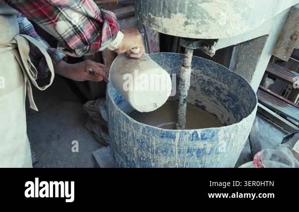 Close-up of liquid clay mud swirling in an industrial mixer within a ...