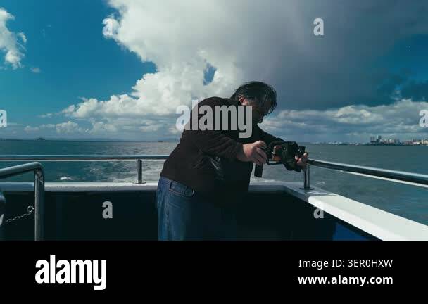 A man takes photos while traveling on a ferry, capturing moments of the ...