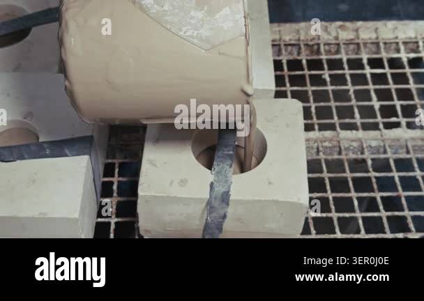 Professional shot of pouring liquid clay slip into a plaster mold ...