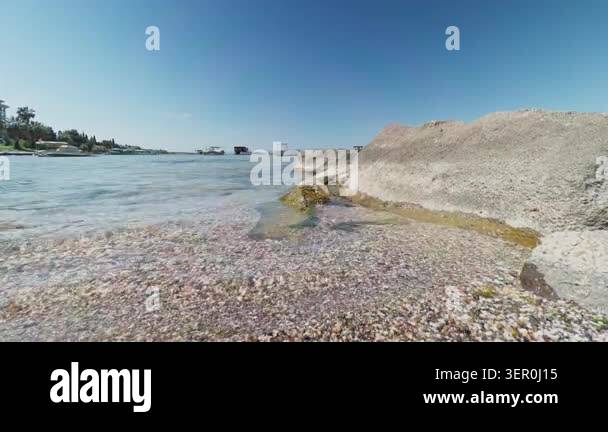 High resolution cinematic shot of little pebbles on the shoreline near ...