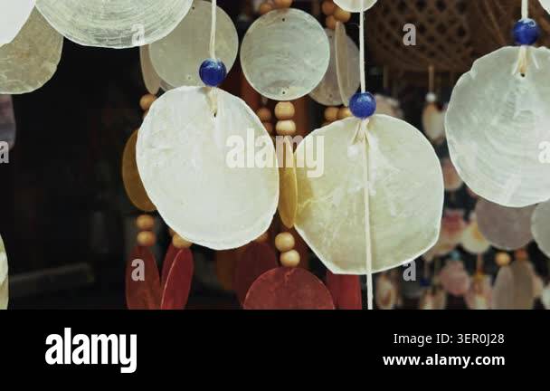 Cinematic high resolution shot of handmade seashell wind chimes and ...