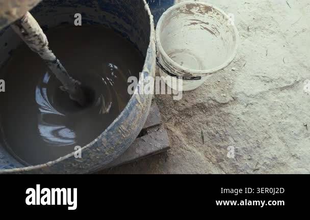 Close-up of liquid clay mud swirling in an industrial mixer within a ...