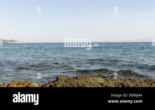 Cinematic high resolution shot of a man riding a jet ski across the ...
