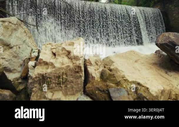 Wide scenic shot of a powerful waterfall cascade flowing into a rocky ...