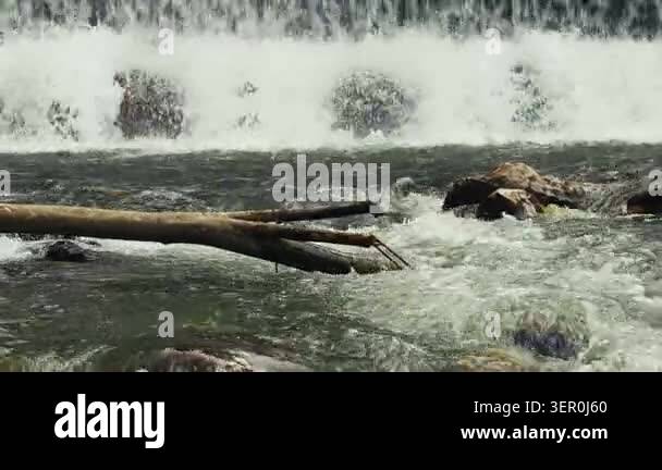 Wide scenic shot of a powerful waterfall cascade flowing into a rocky ...