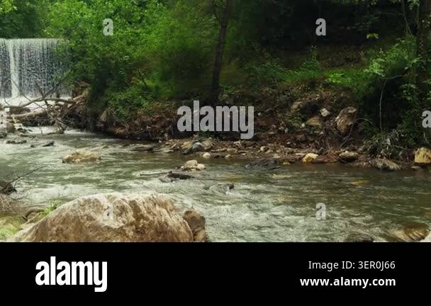 Wide scenic shot of a powerful waterfall cascade flowing into a rocky ...