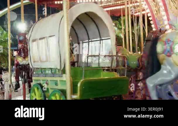 Cinematic close up of a vintage carousel spinning at an amusement park ...