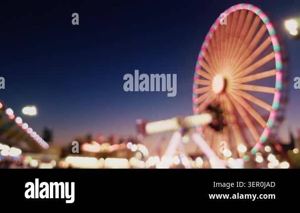 Defocused out of focus shot of spinning amusement park rides during ...