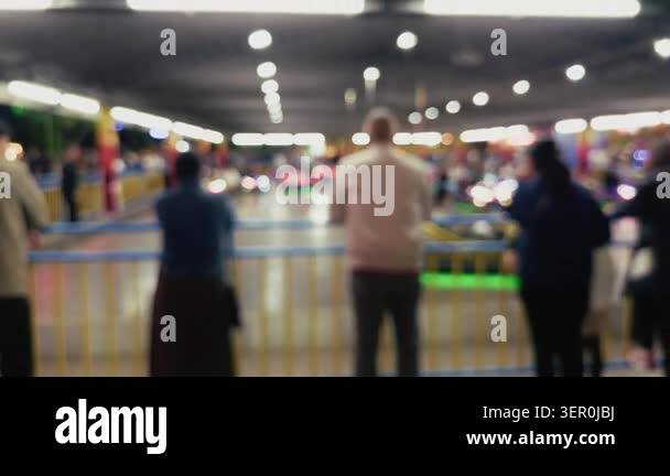 Defocused out of focus shot of spinning amusement park rides during ...