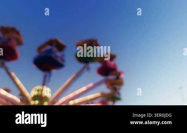 Defocused out of focus shot of spinning amusement park rides during ...